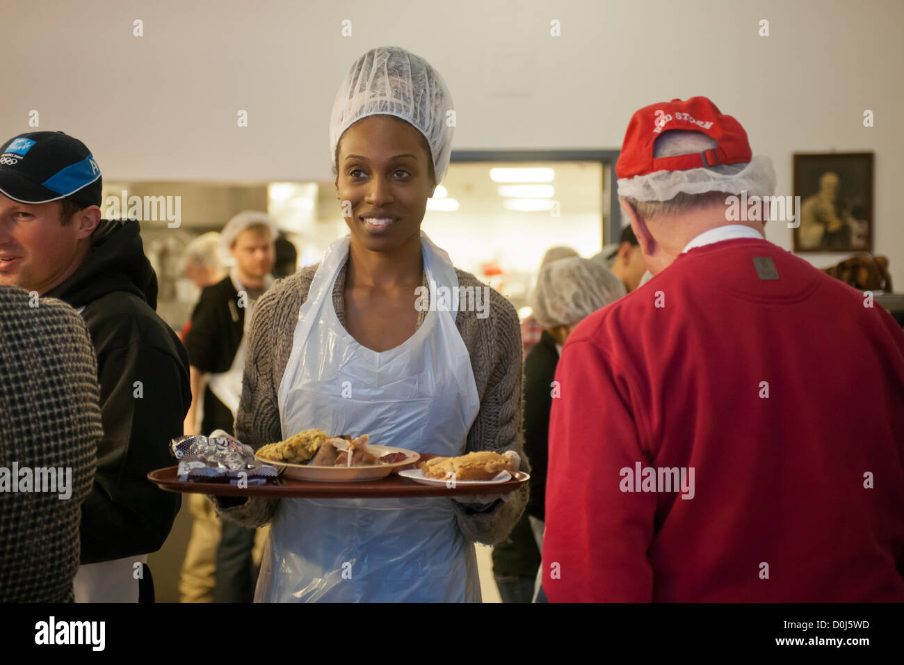 Volunteers and staff of St. John's Bread and Life, prepare and serve a ...