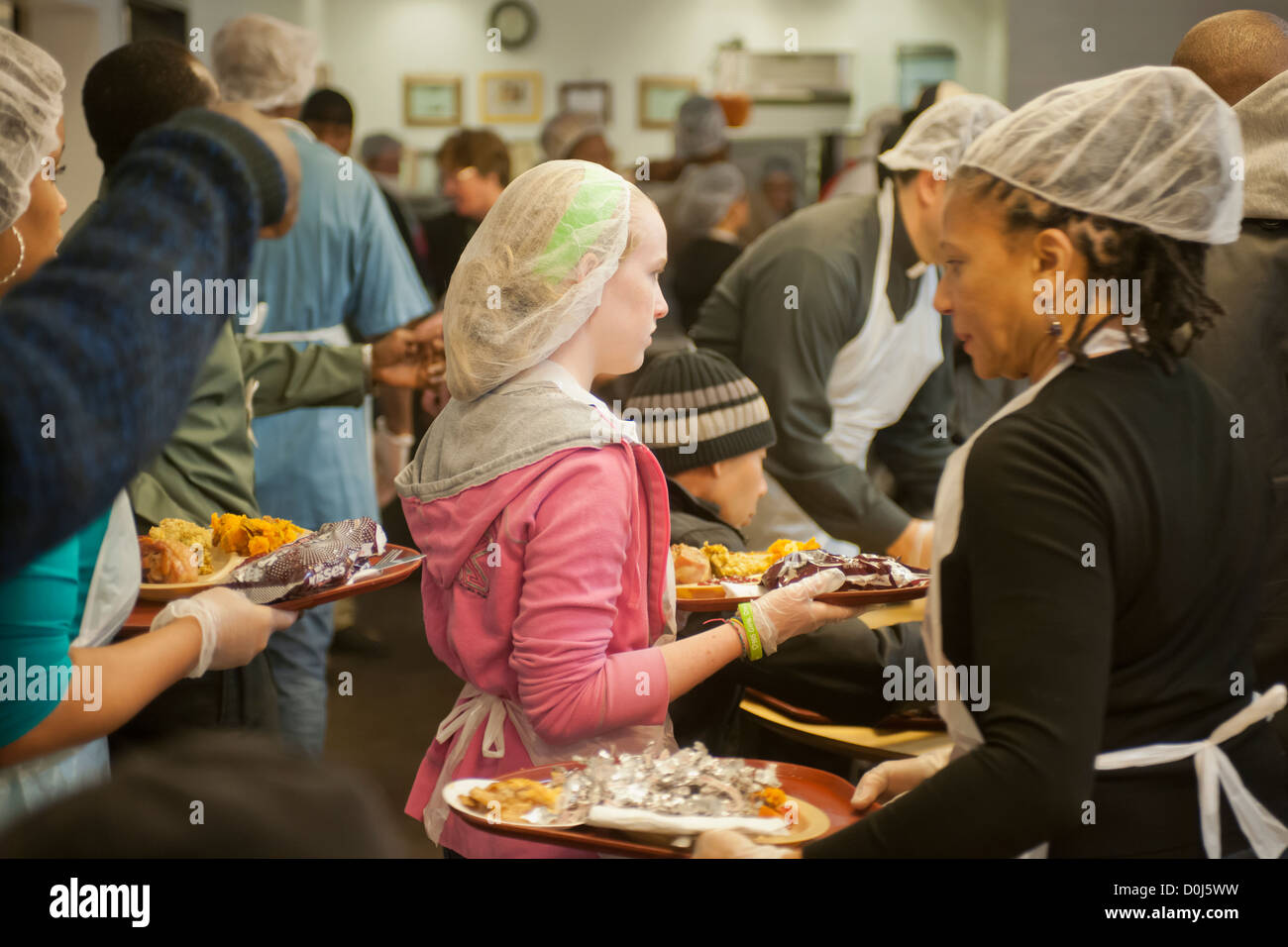 Volunteers and staff of St. John's Bread and Life, prepare and serve a ...