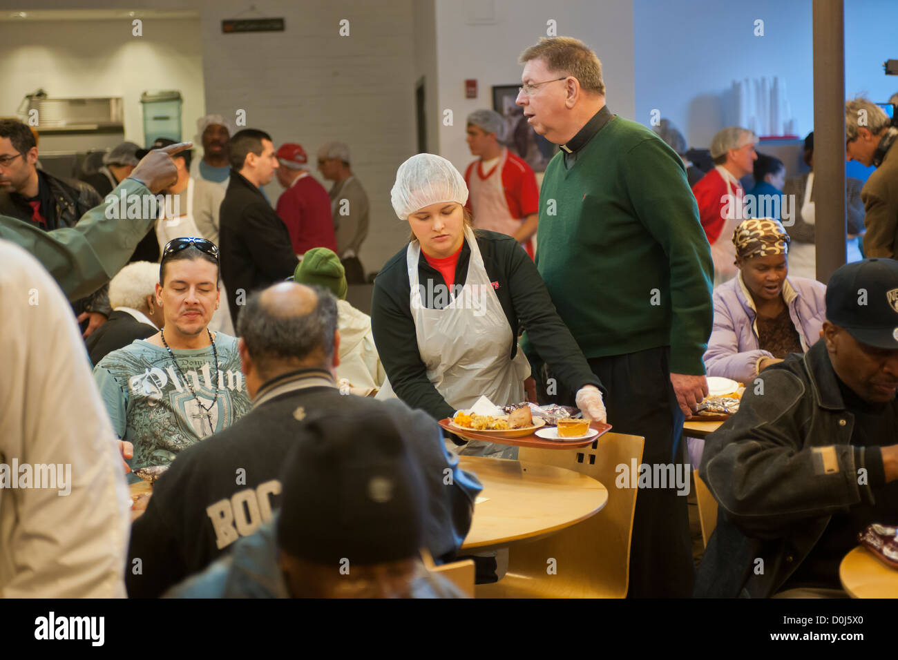 Volunteers and staff of St. John's Bread and Life, prepare and serve a ...