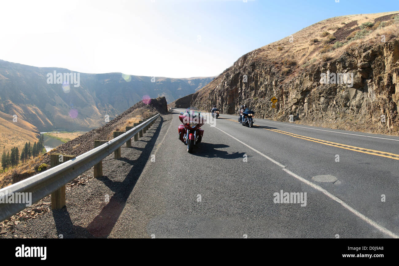 A parked motorcycle and two motorcycles with riders tour on the ...