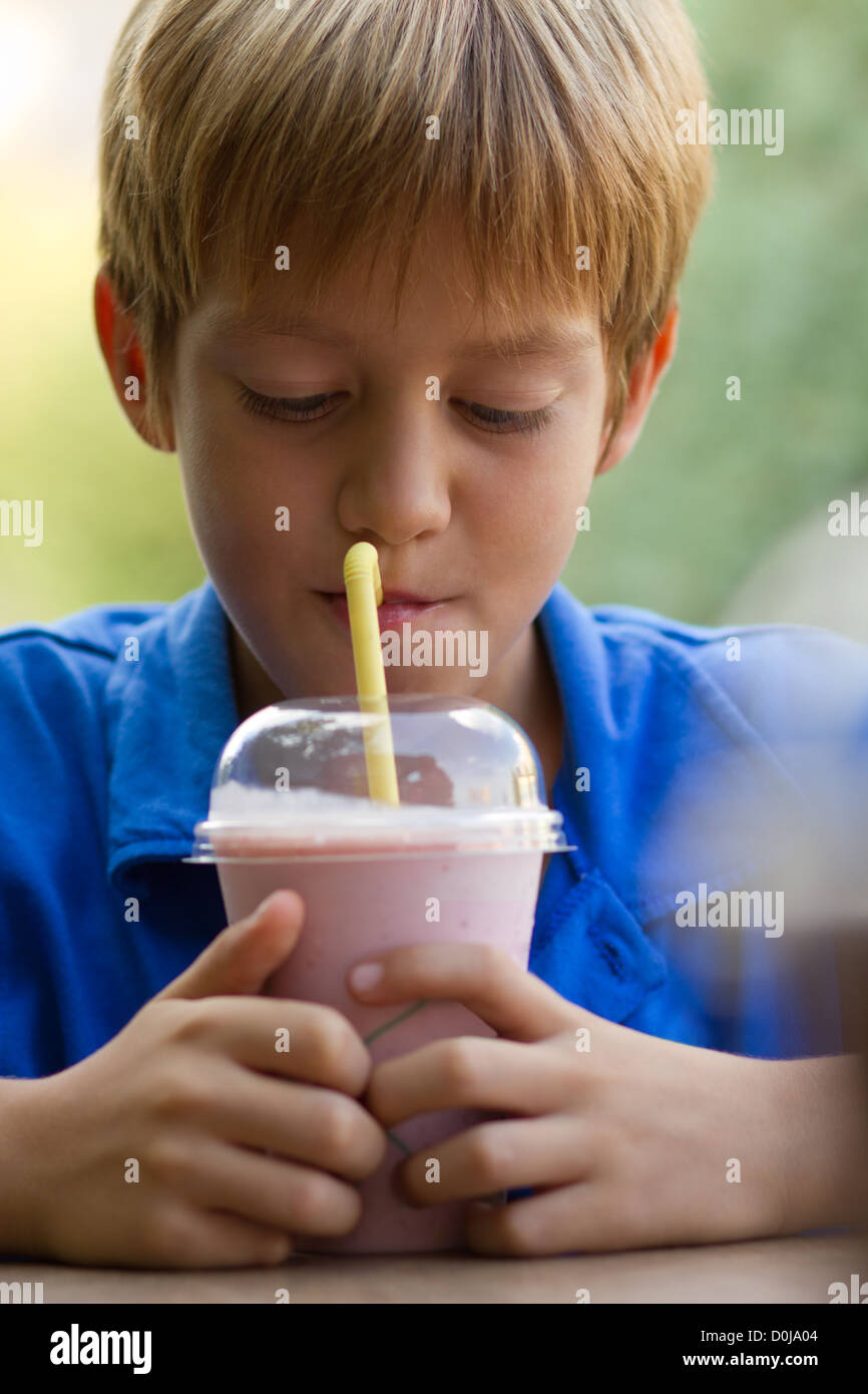 Little brother and sister drinking milkshakes in a cafe outdoors Stock ...
