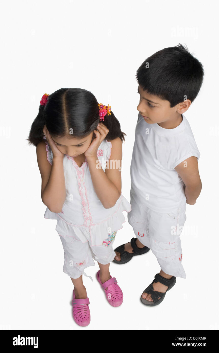 Girl covering her ears while her brother talking Stock Photo - Alamy