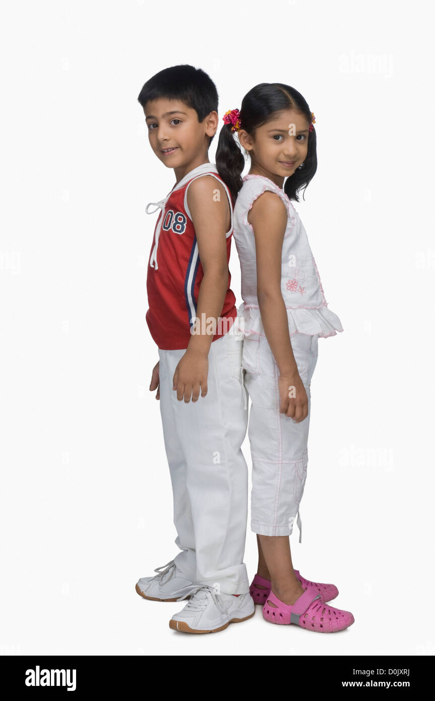 Portrait of two children standing back to back Stock Photo - Alamy