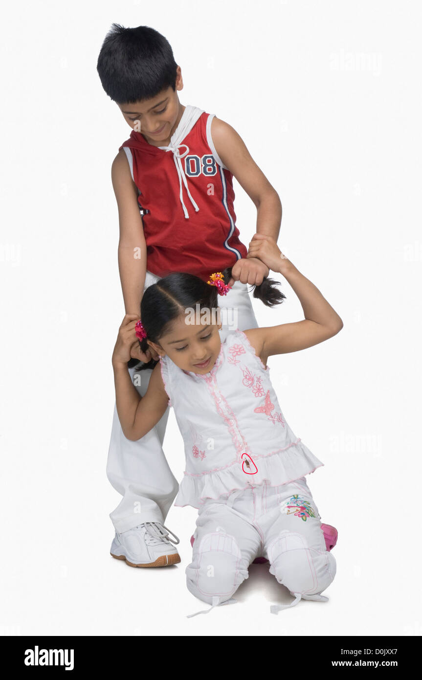 Boy pulling hair of his sister Stock Photo - Alamy