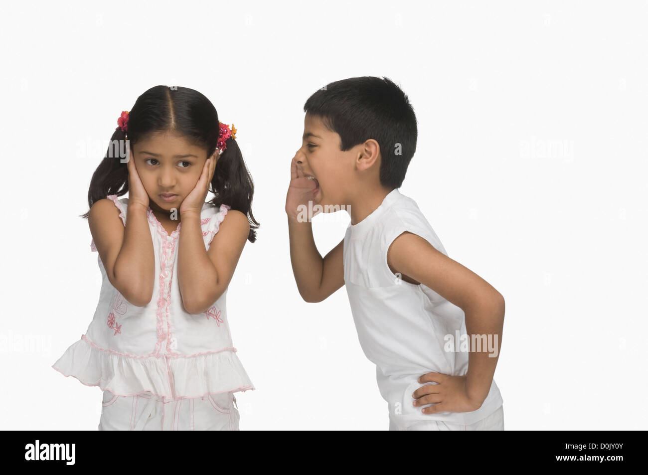 Girl covering her ears while her brother shouting Stock Photo - Alamy