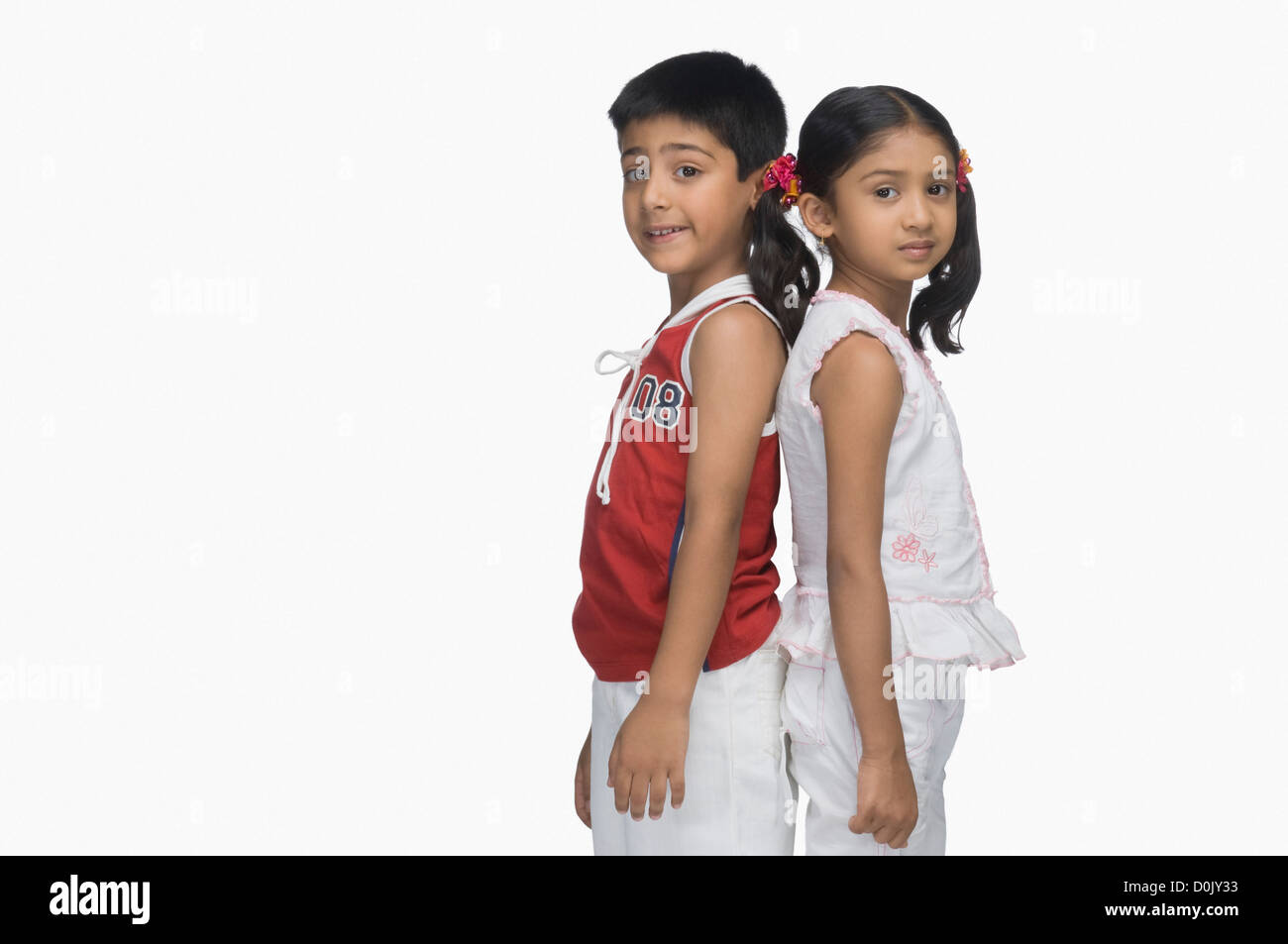 Portrait of two children standing back to back Stock Photo - Alamy