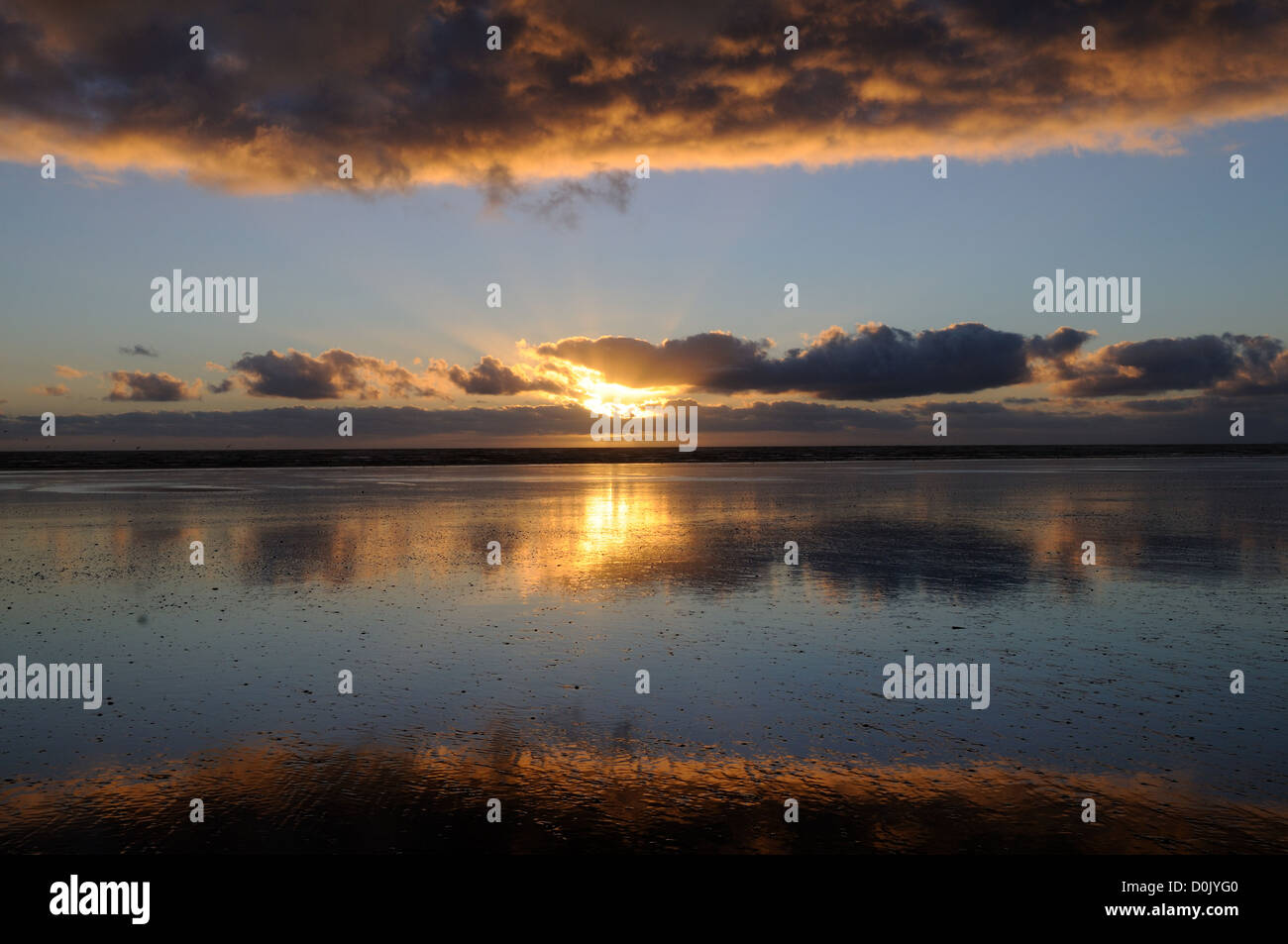 Winter sunset over reflected in Cefn Sidan Beach Pembrey Country park ...