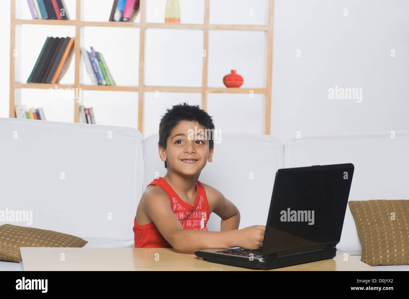 Boy working on a laptop and smiling Stock Photo - Alamy