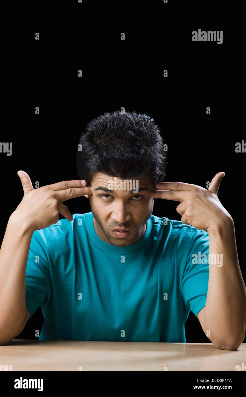 Man making gun signs with fingers at his temples Stock Photo - Alamy