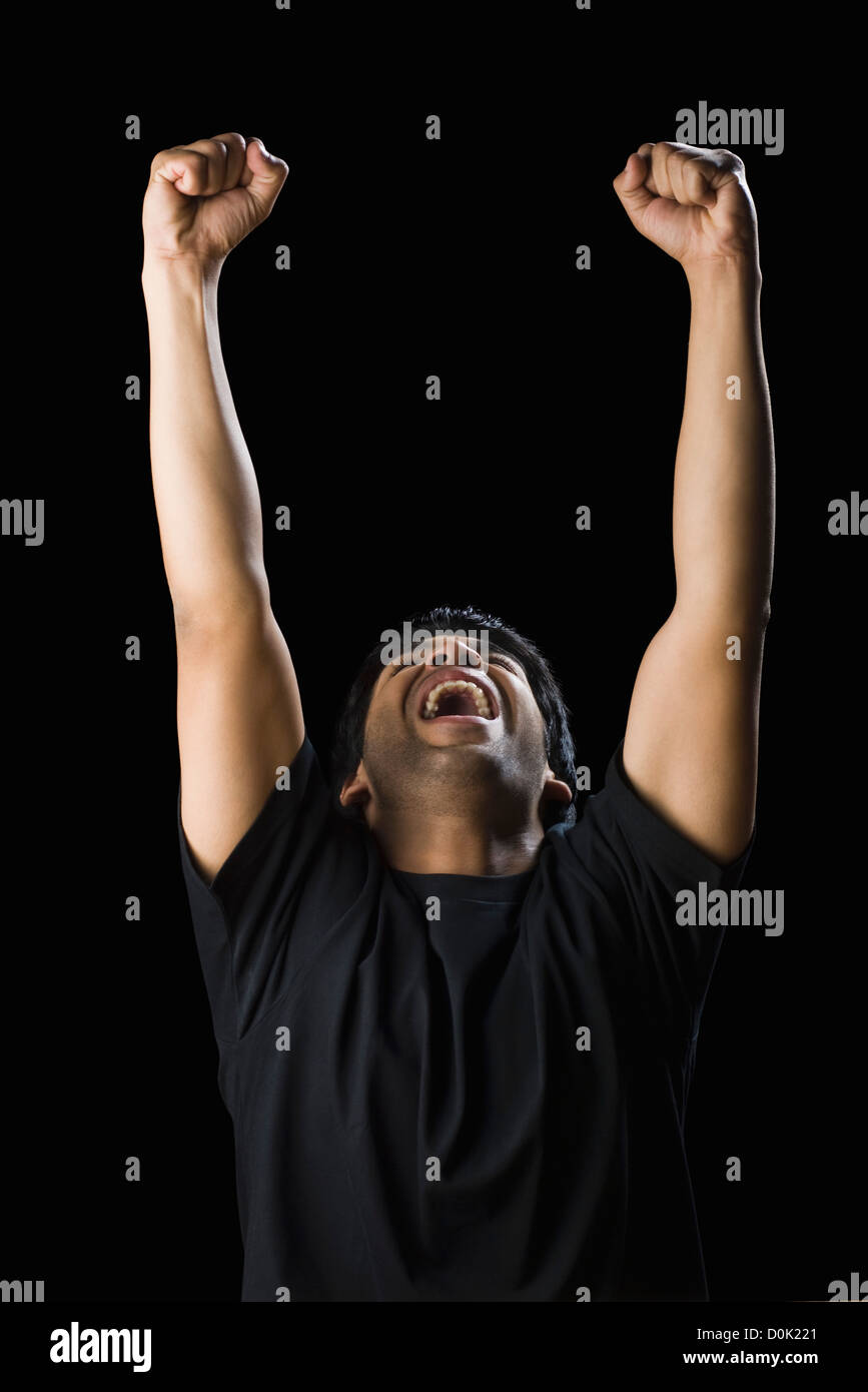 Man shouting with his arms raised Stock Photo - Alamy