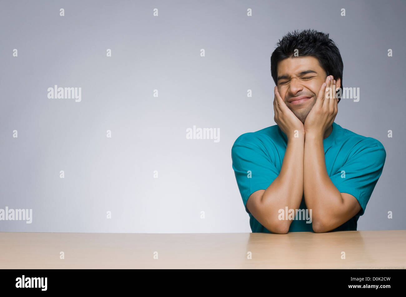 Man leaning on elbows and making a face Stock Photo - Alamy
