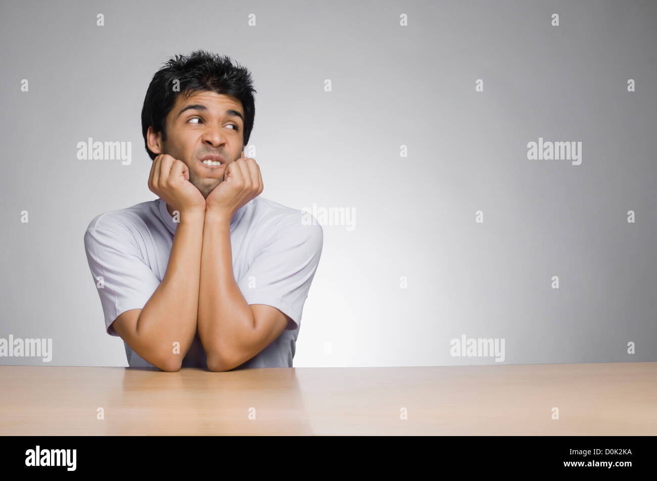 Man leaning on elbows and making a face Stock Photo - Alamy