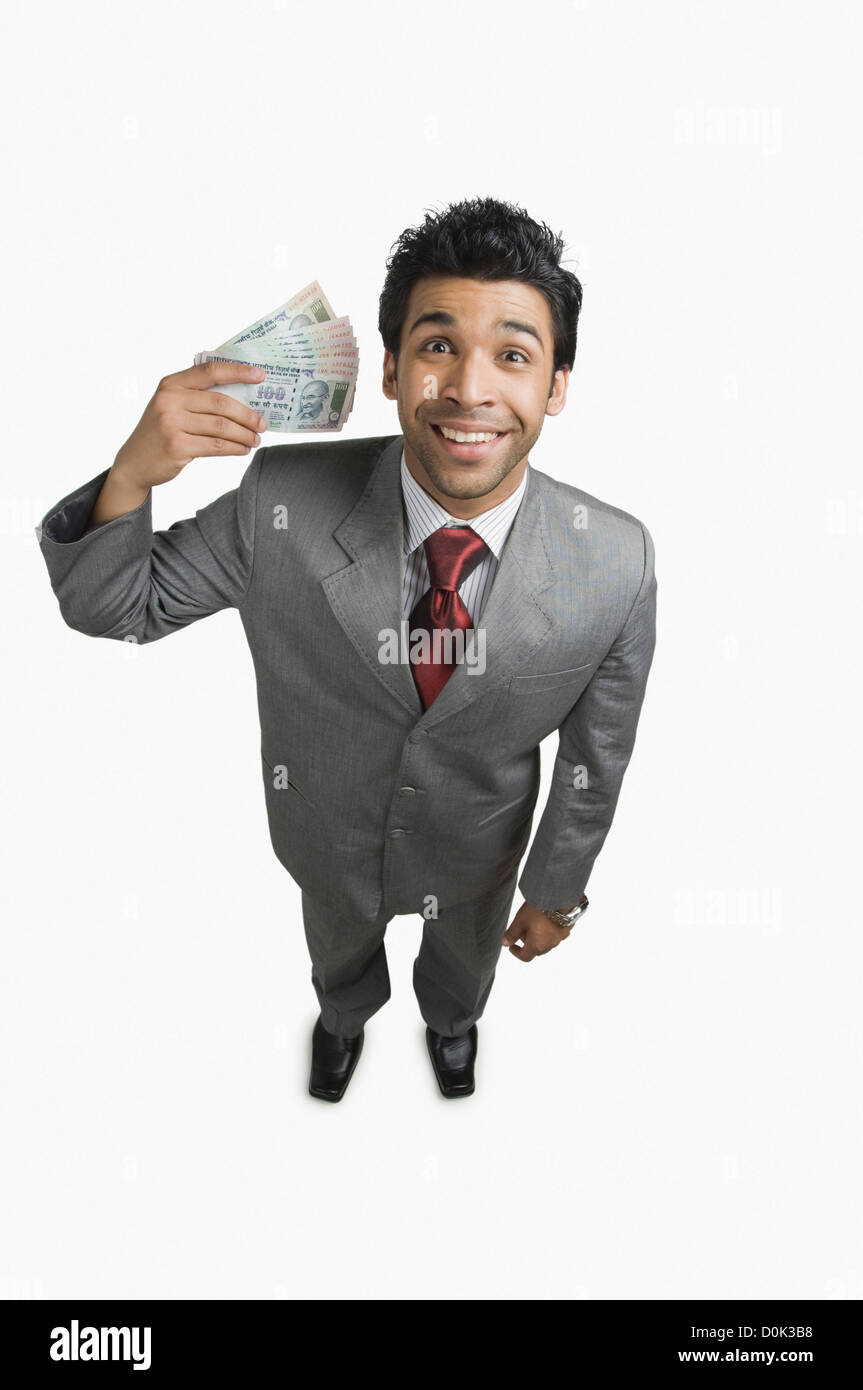 Businessman holding money and smiling Stock Photo - Alamy