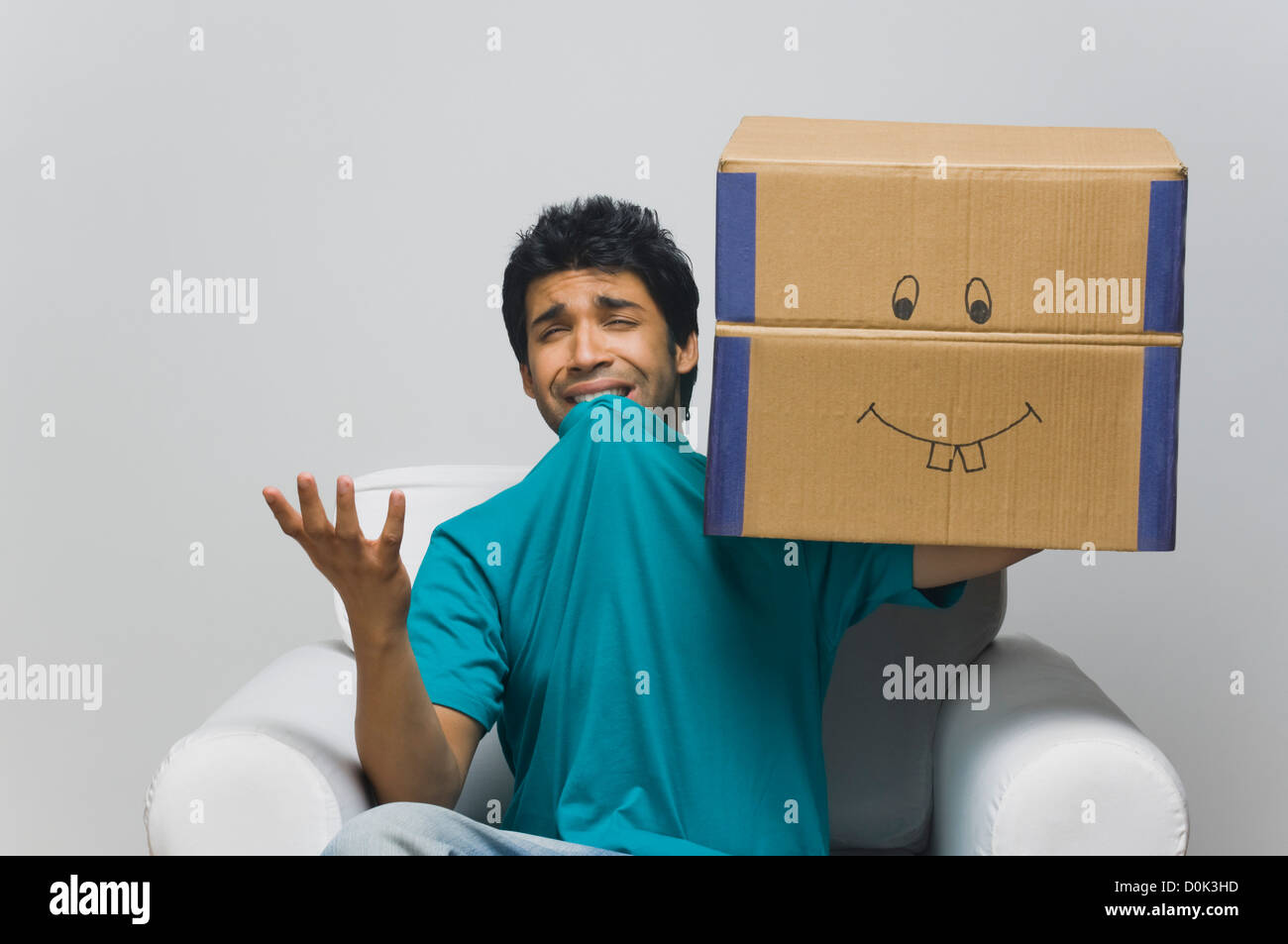 Man holding a cardboard box and looking sad Stock Photo - Alamy