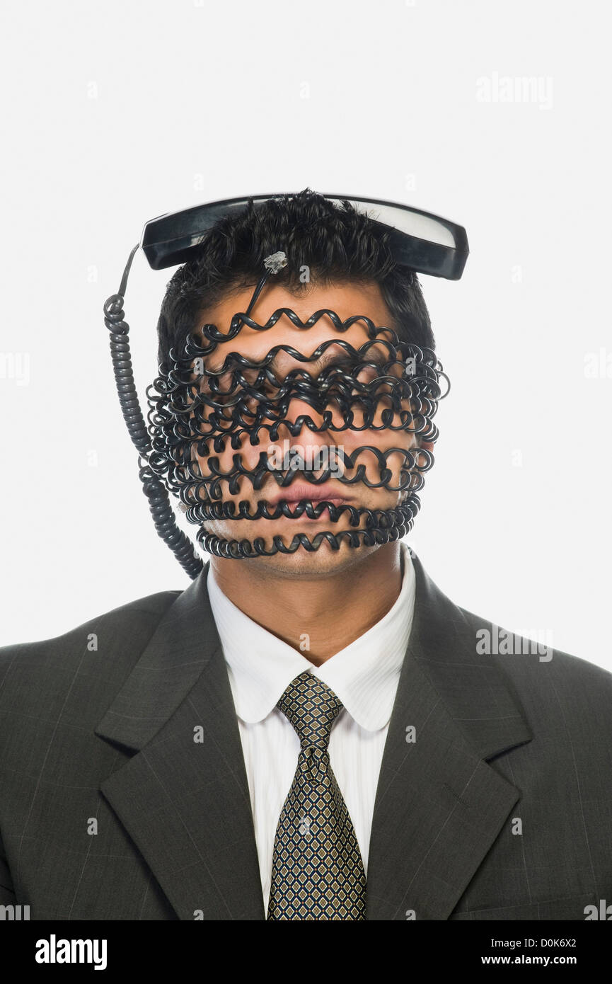 Businessman's face wrapped with telephone cord with it's receiver on ...