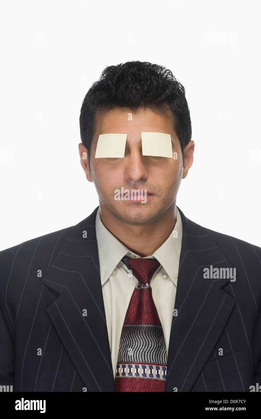 Adhesive notes on a businessman's eyes Stock Photo - Alamy