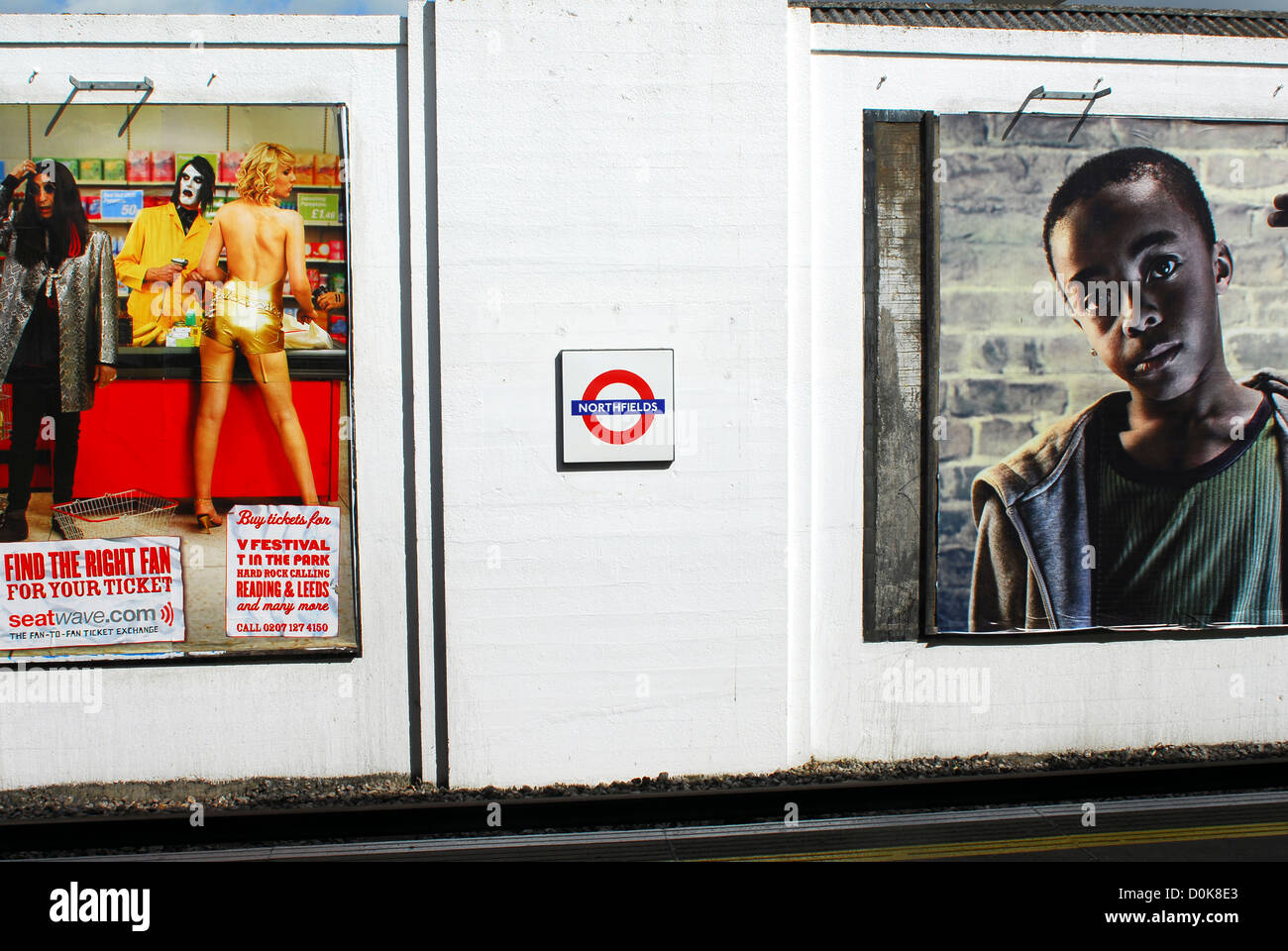 Posters on a tube station wall at Northfields Stock Photo - Alamy