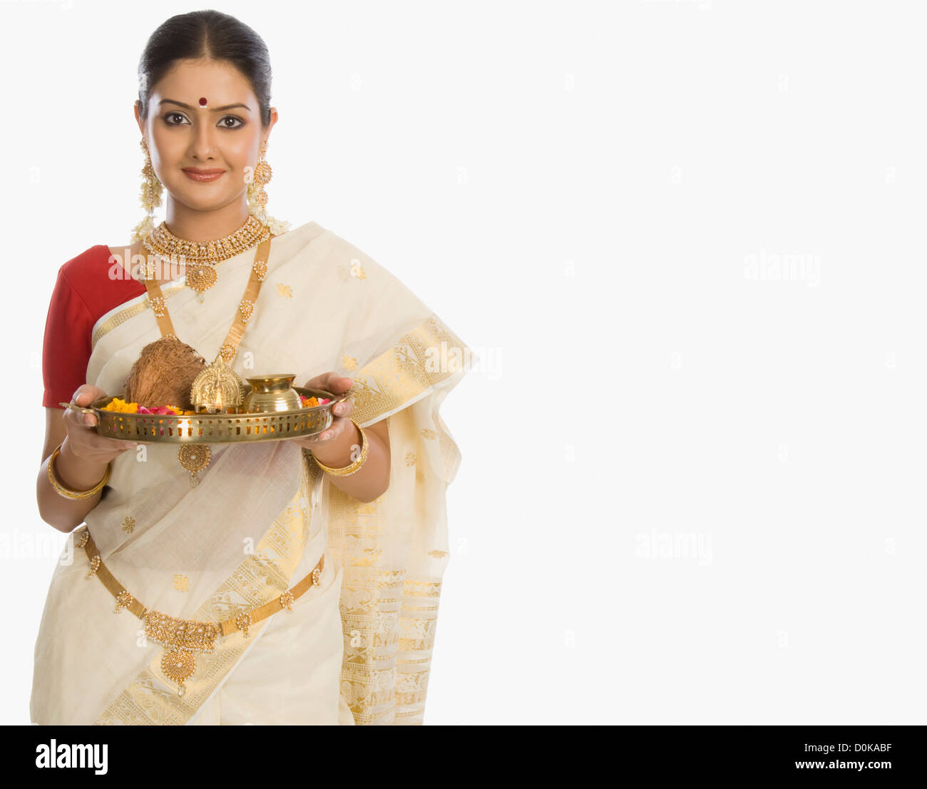Portrait of a South Indian woman holding a plate of religious offerings ...