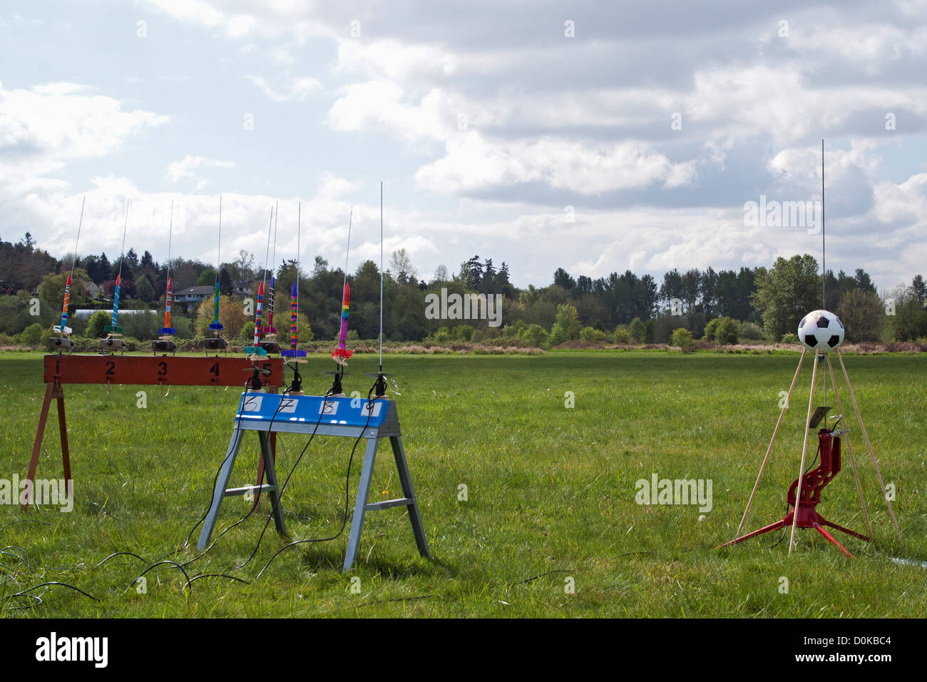 Nine rockets in two rows and a soccer-ball rocket at a rocketry launch ...