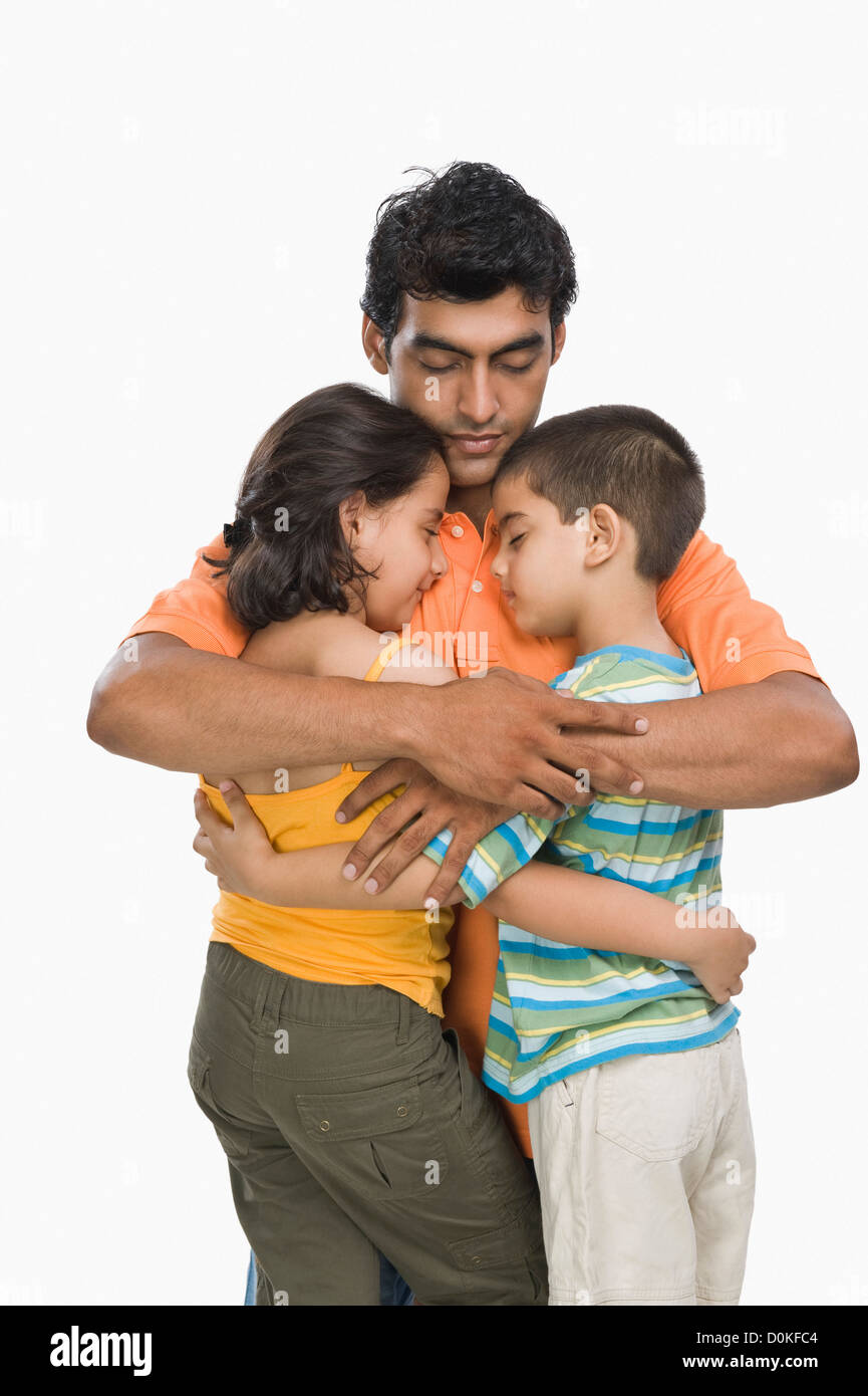 Close-up of a man hugging his children Stock Photo - Alamy