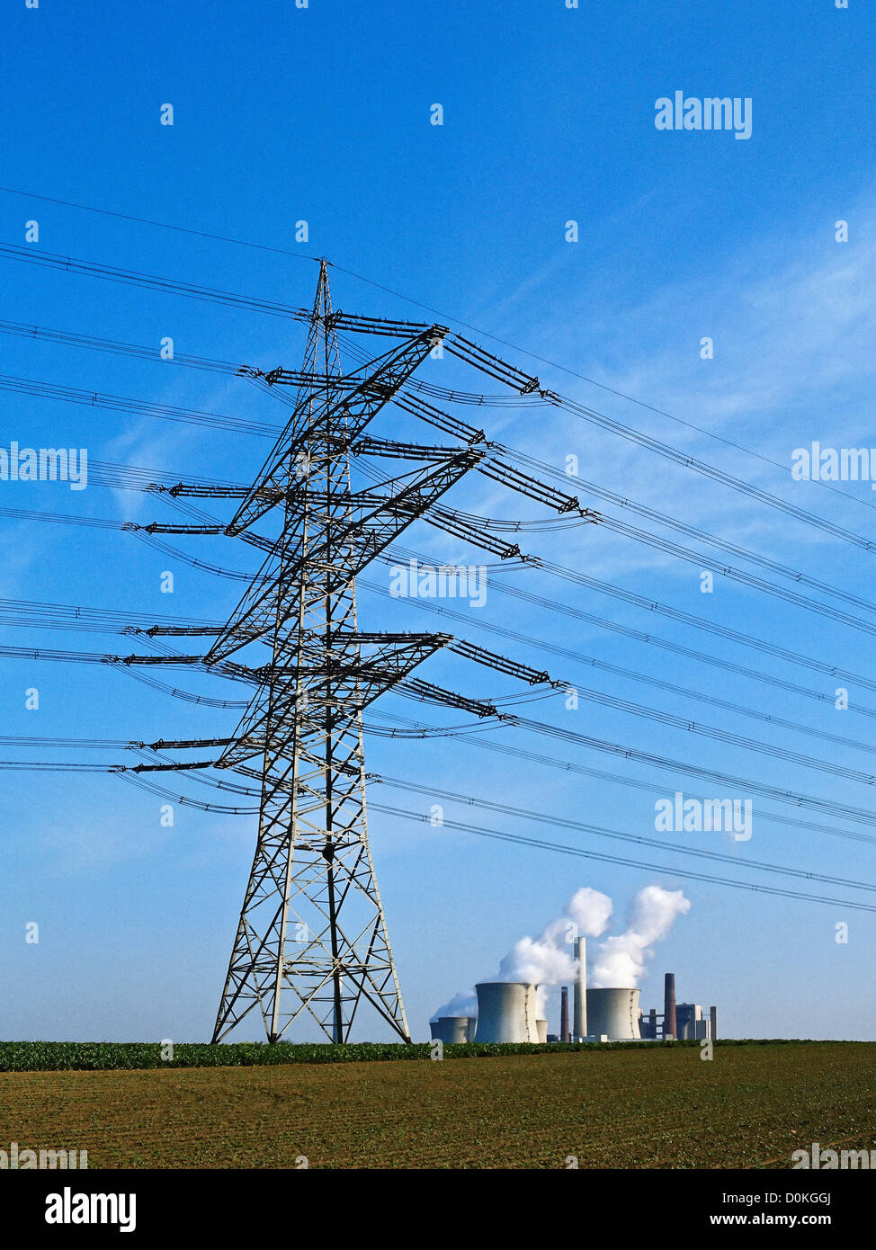 A power plant with a skein of power lines and a utility tower in the ...
