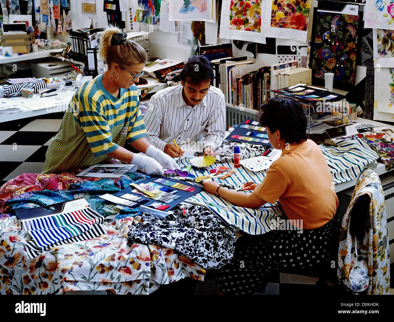 Designers at work with fabric samples in the design department of a ...