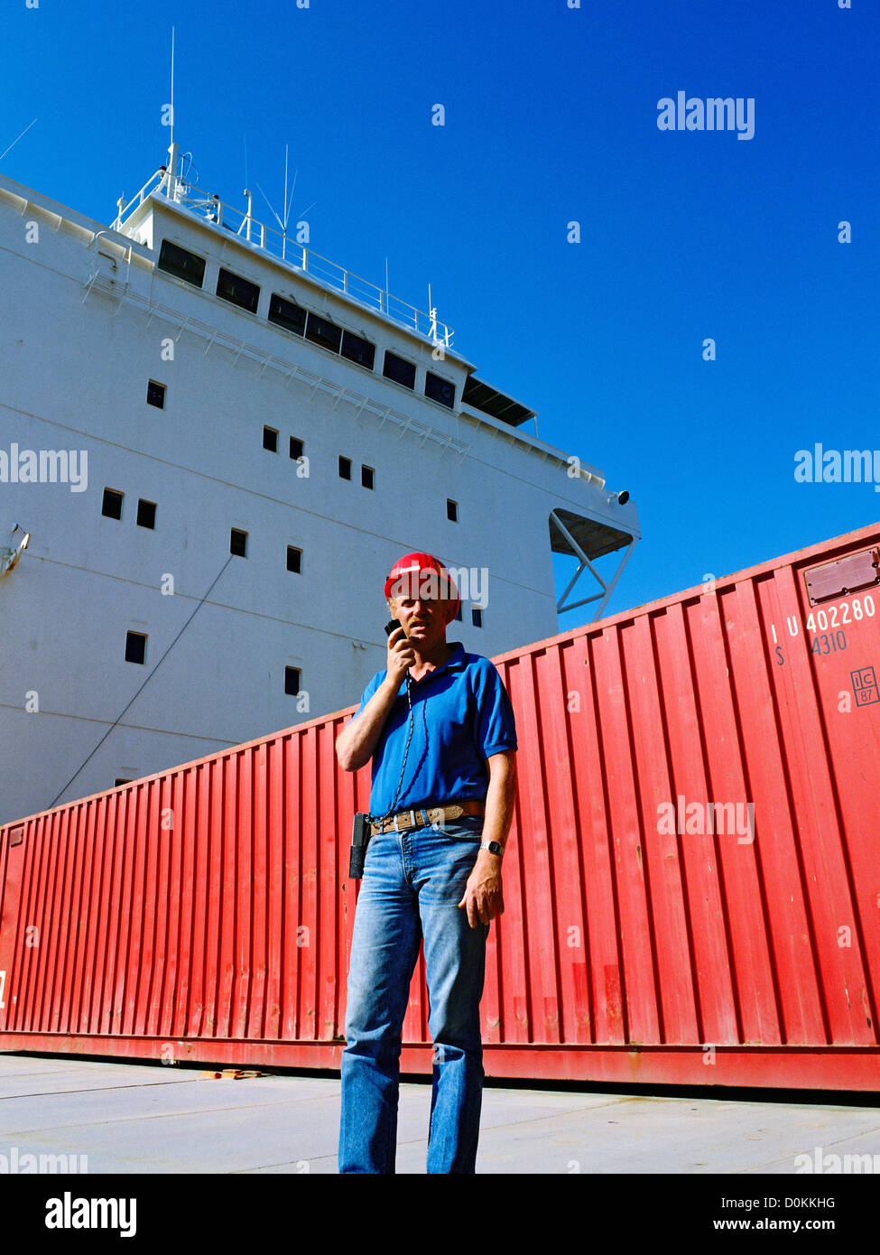 A dock worker in front of a cargo container on a cargo ship Stock Photo ...