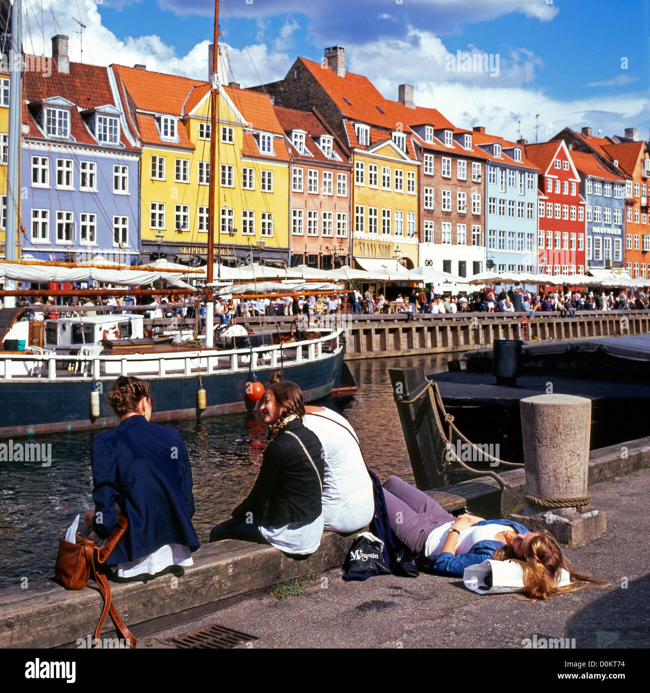Nyhavn Harbour Copenhagen Denmark young women relaxing on the quay ...