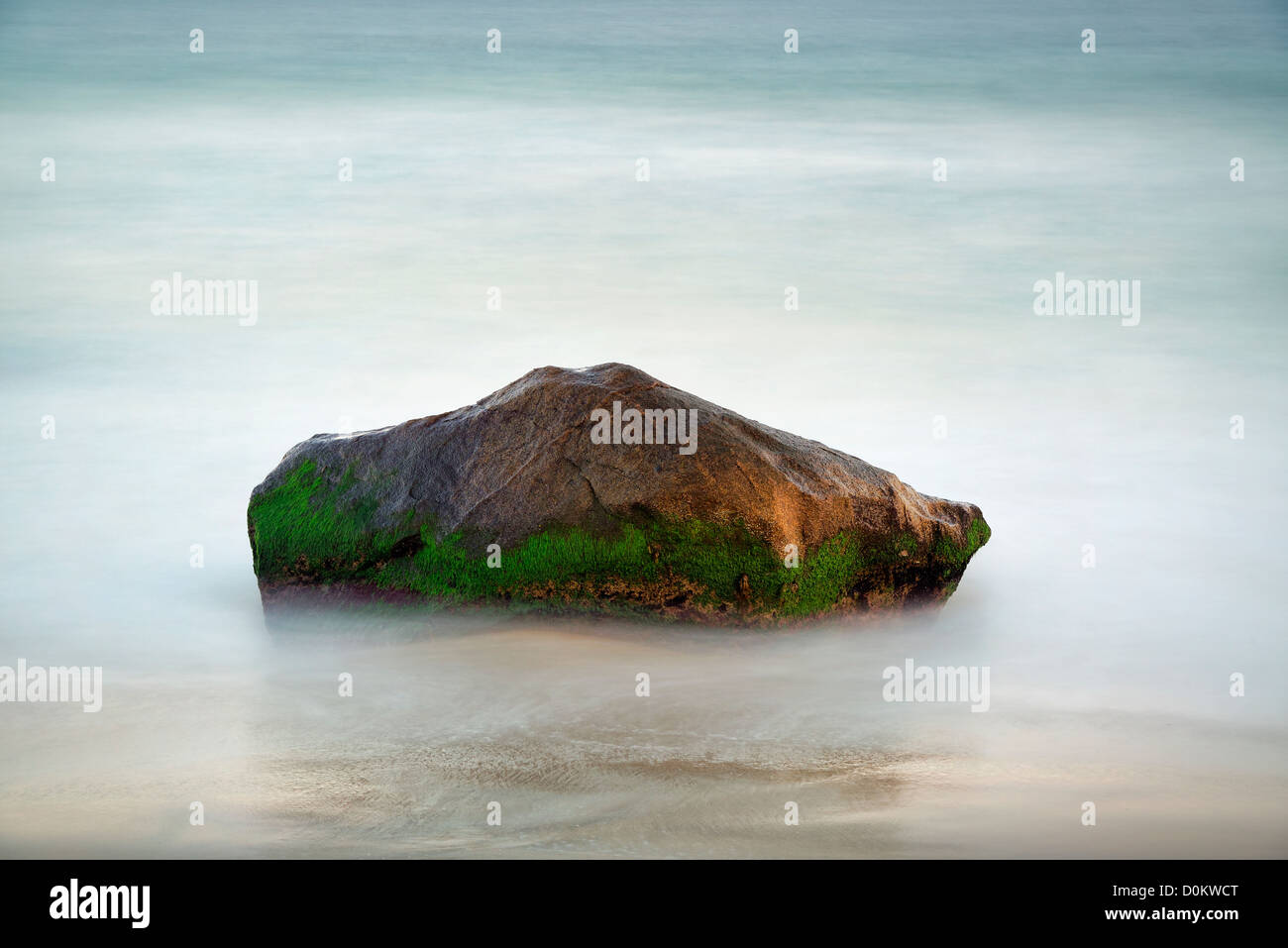 Rock with moving ocean water Stock Photo - Alamy