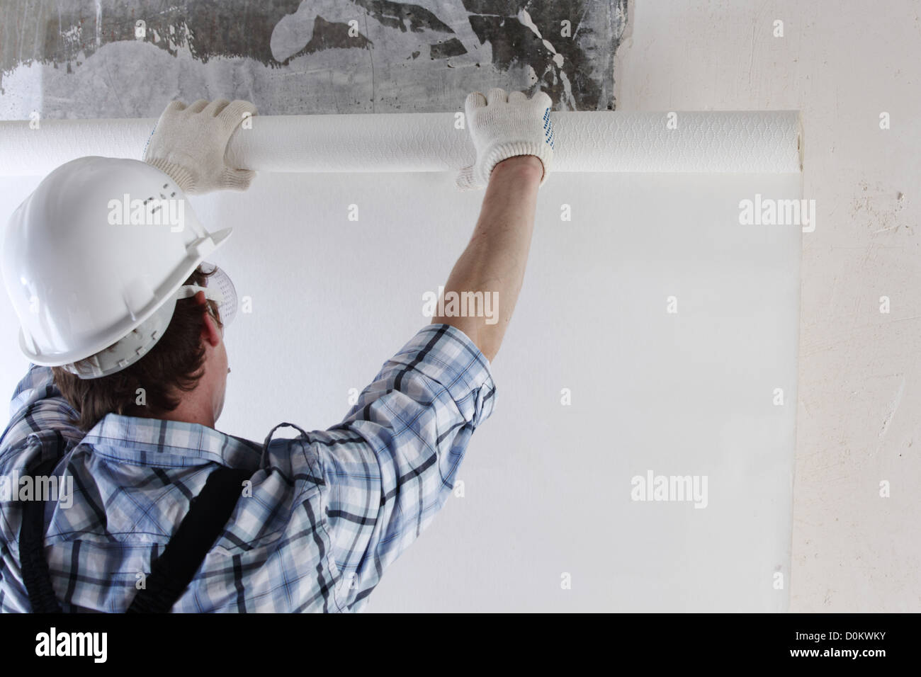 worker attaching wallpaper to wall Stock Photo - Alamy