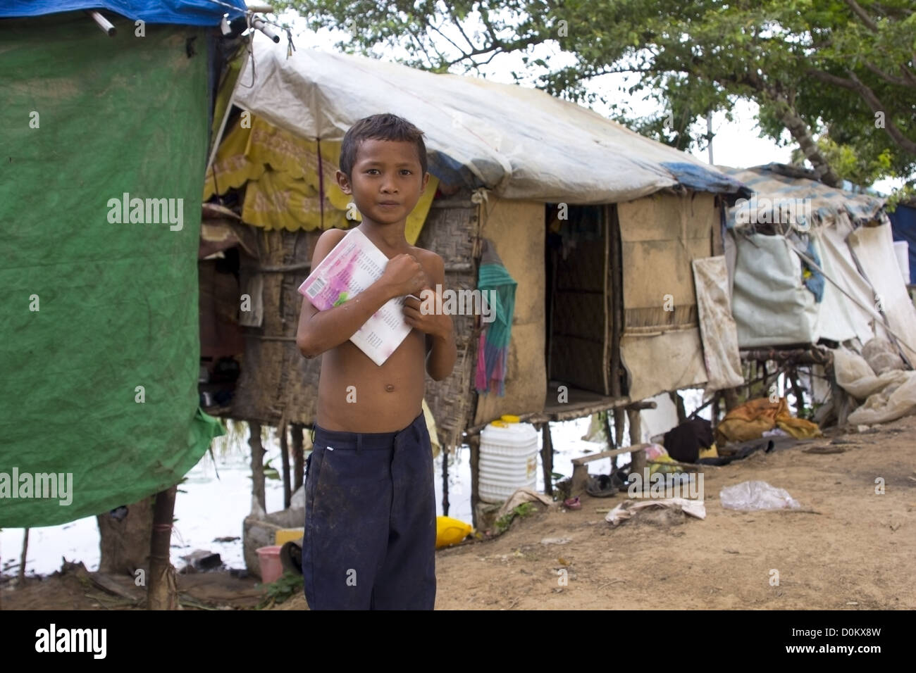 Boy in slum holding book want to go school Stock Photo - Alamy