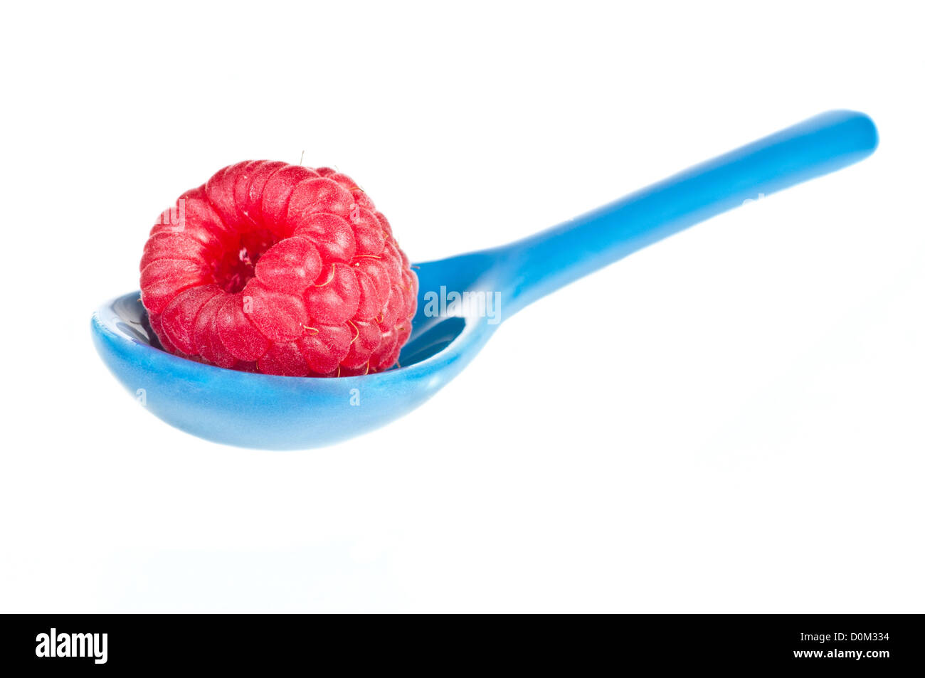 Raspberry in a blue little spoon over a white background Stock Photo ...