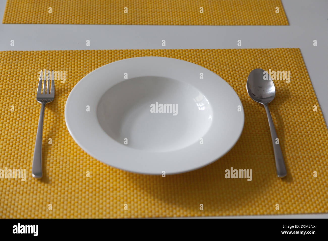 Empty plate on dinner table Stock Photo - Alamy