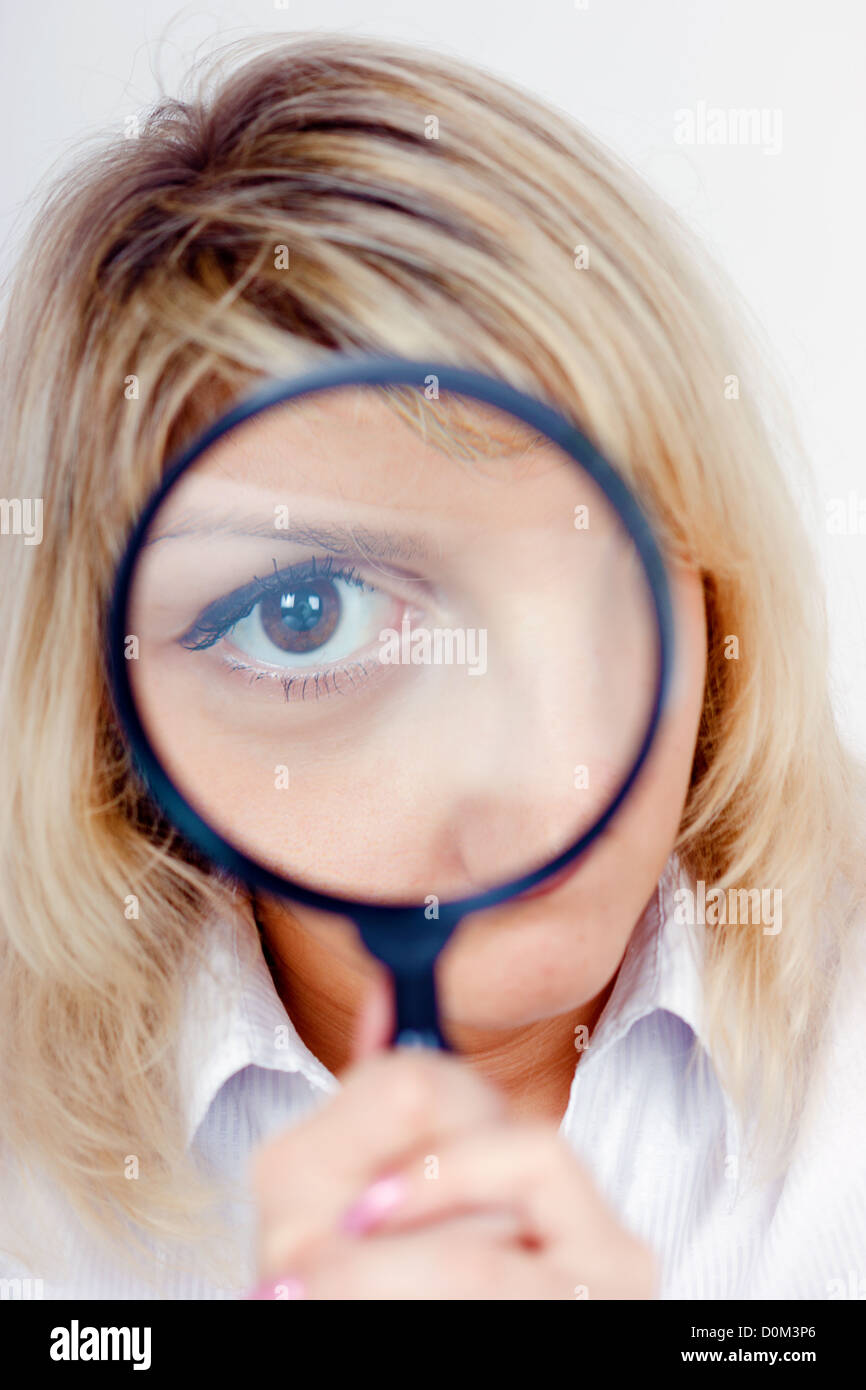 young woman looking through a magnifying glass Stock Photo - Alamy