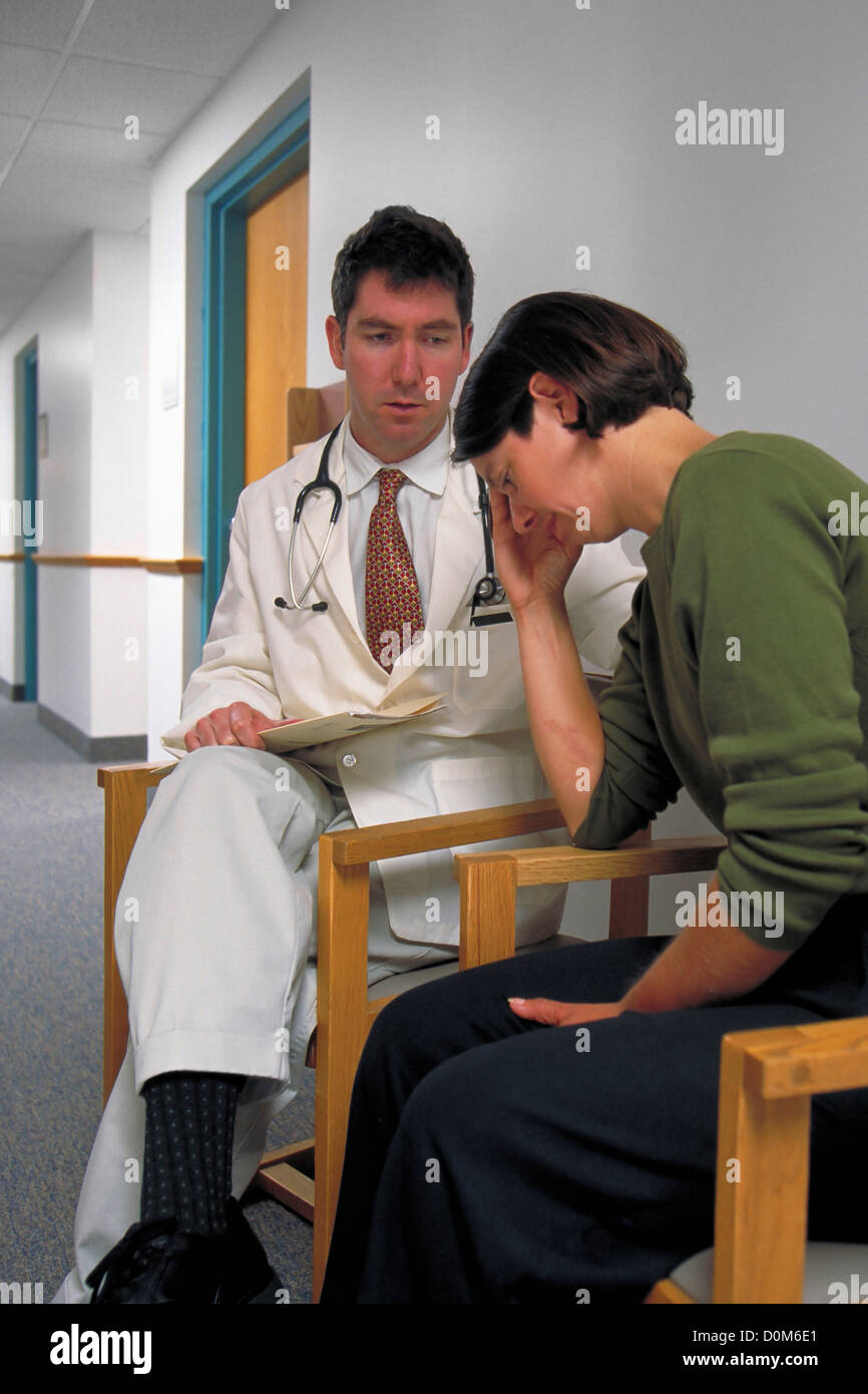 Doctor Relays Diagnosis to Distressed Woman in Hospital Hallway Stock ...