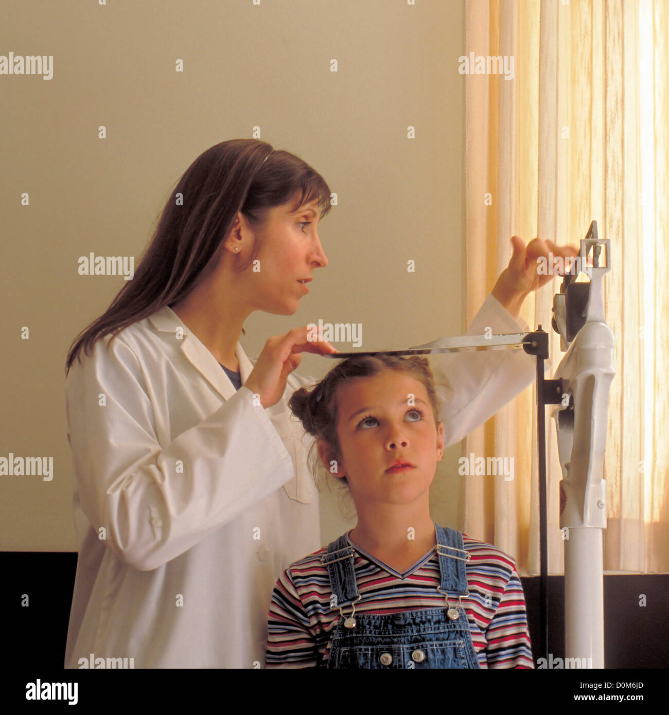 Doctor Measuring Height of Young Girl Stock Photo - Alamy