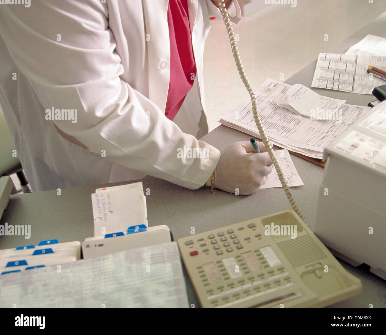 Lab Technician Takes Notes While on Telephone Stock Photo - Alamy