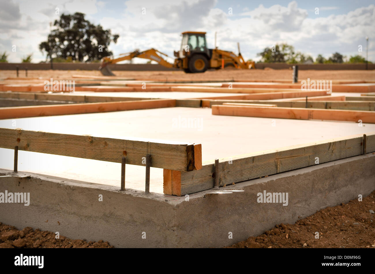 New Home Foundation with Tractor in Background Stock Photo - Alamy