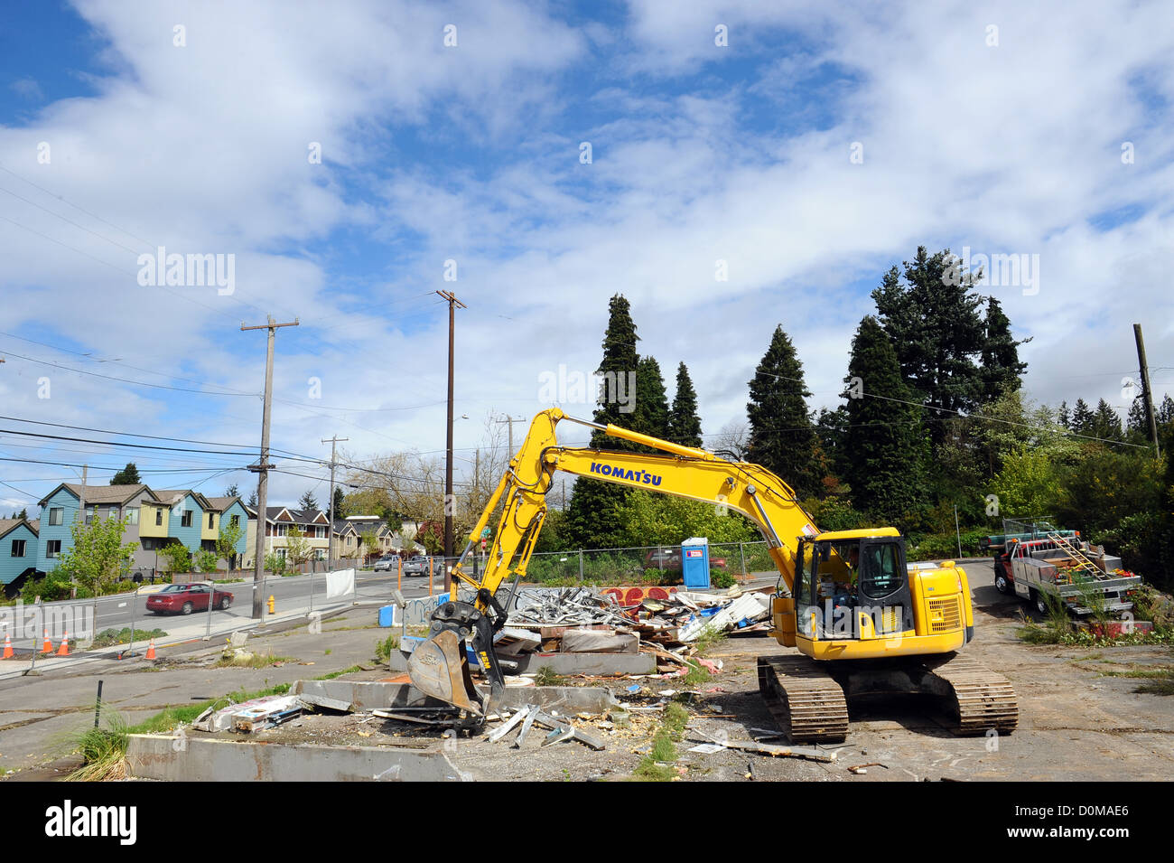 Excavator on corner lot digging up asphalt Stock Photo - Alamy