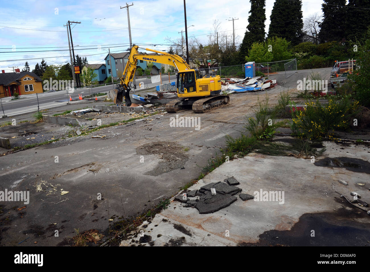 Excavator on corner lot digging up asphalt Stock Photo - Alamy