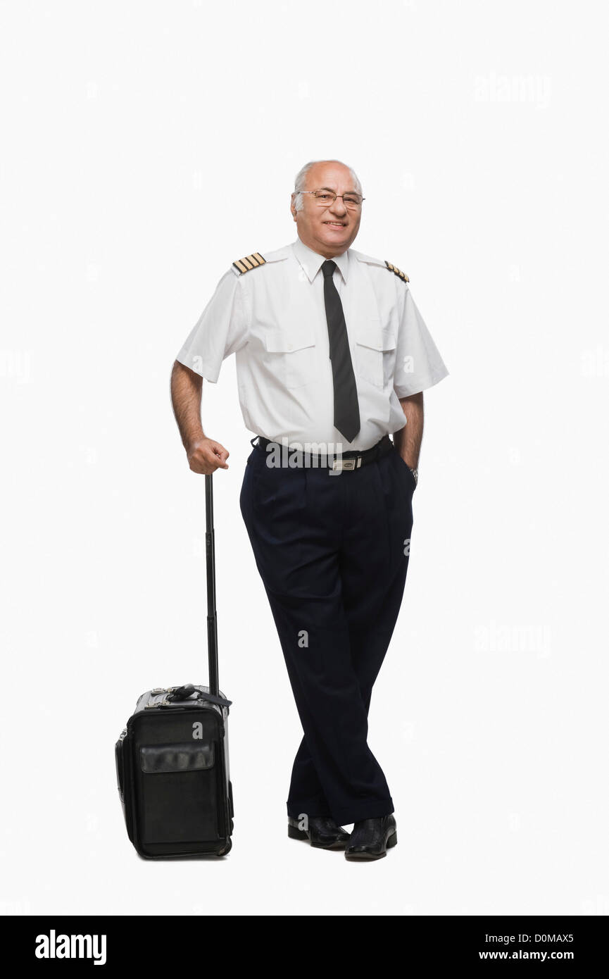 Portrait of a pilot carrying a luggage and smiling Stock Photo - Alamy