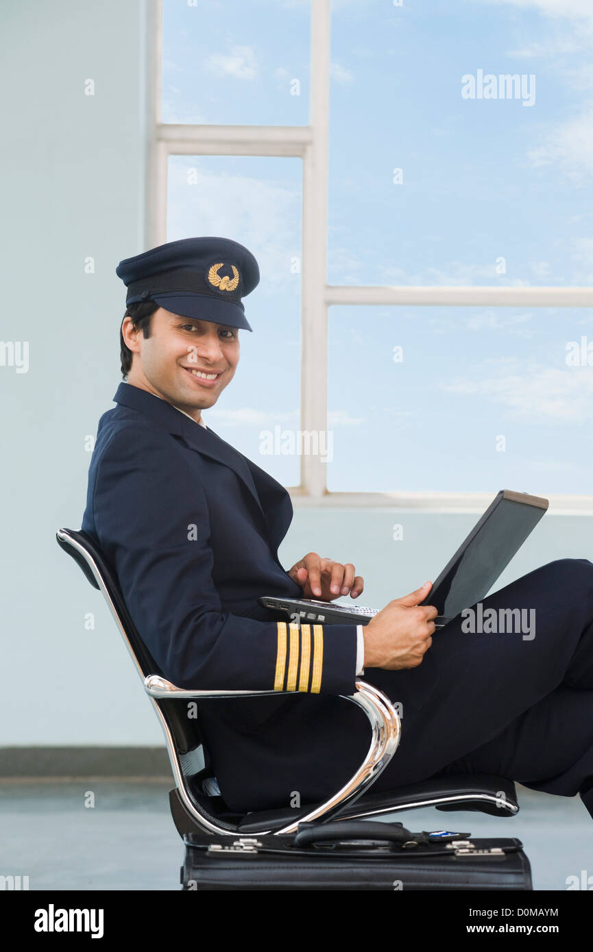 Pilot using a laptop at an airport Stock Photo - Alamy