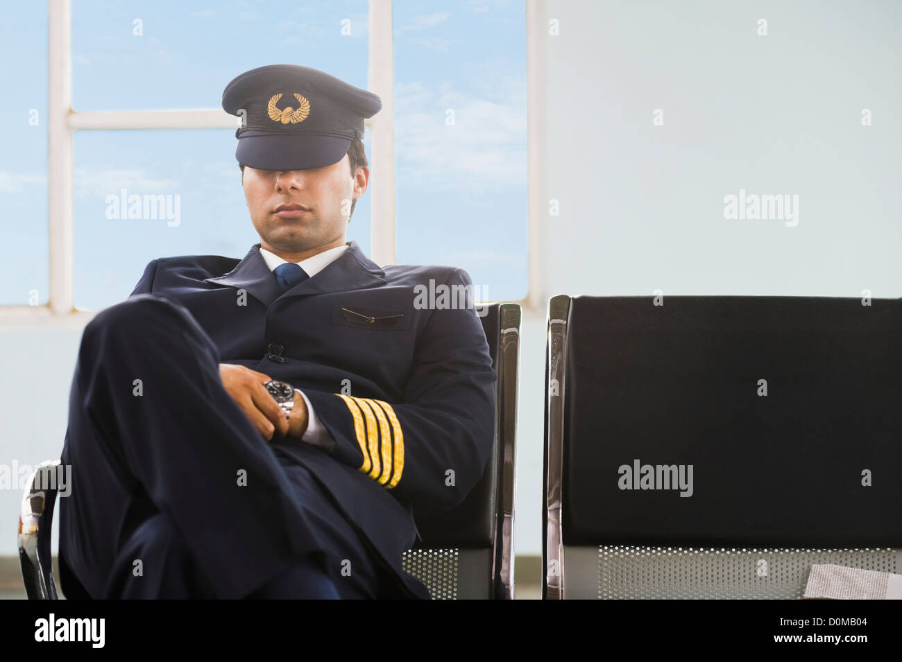 Pilot napping on the bench at an airport Stock Photo - Alamy
