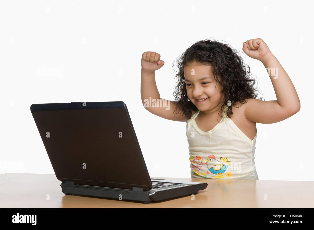 Girl cheering in front of a laptop Stock Photo - Alamy