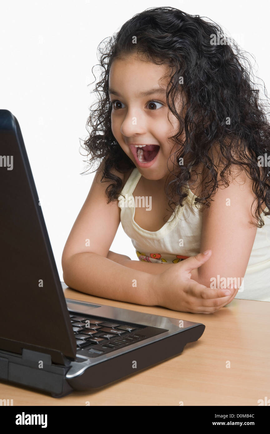 Girl looking surprised in front of a laptop Stock Photo - Alamy