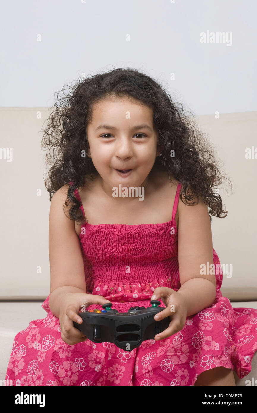 Girl playing a video game and making a funny face Stock Photo - Alamy