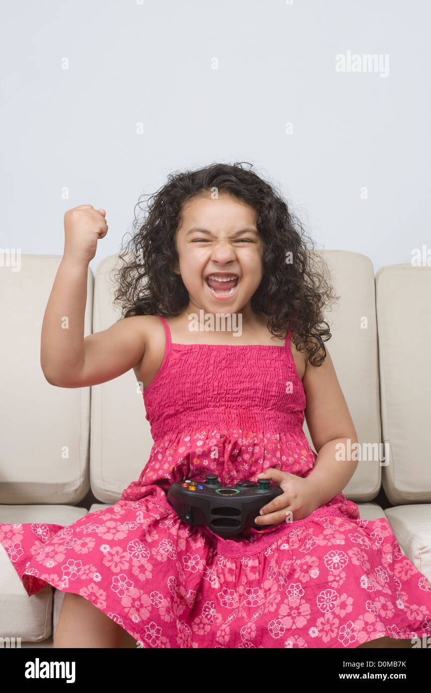 Girl playing a video game and looking excited Stock Photo - Alamy