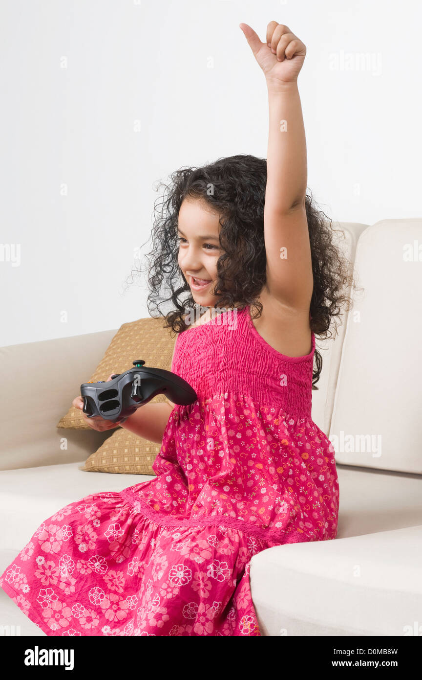 Girl playing a video game and looking excited Stock Photo - Alamy