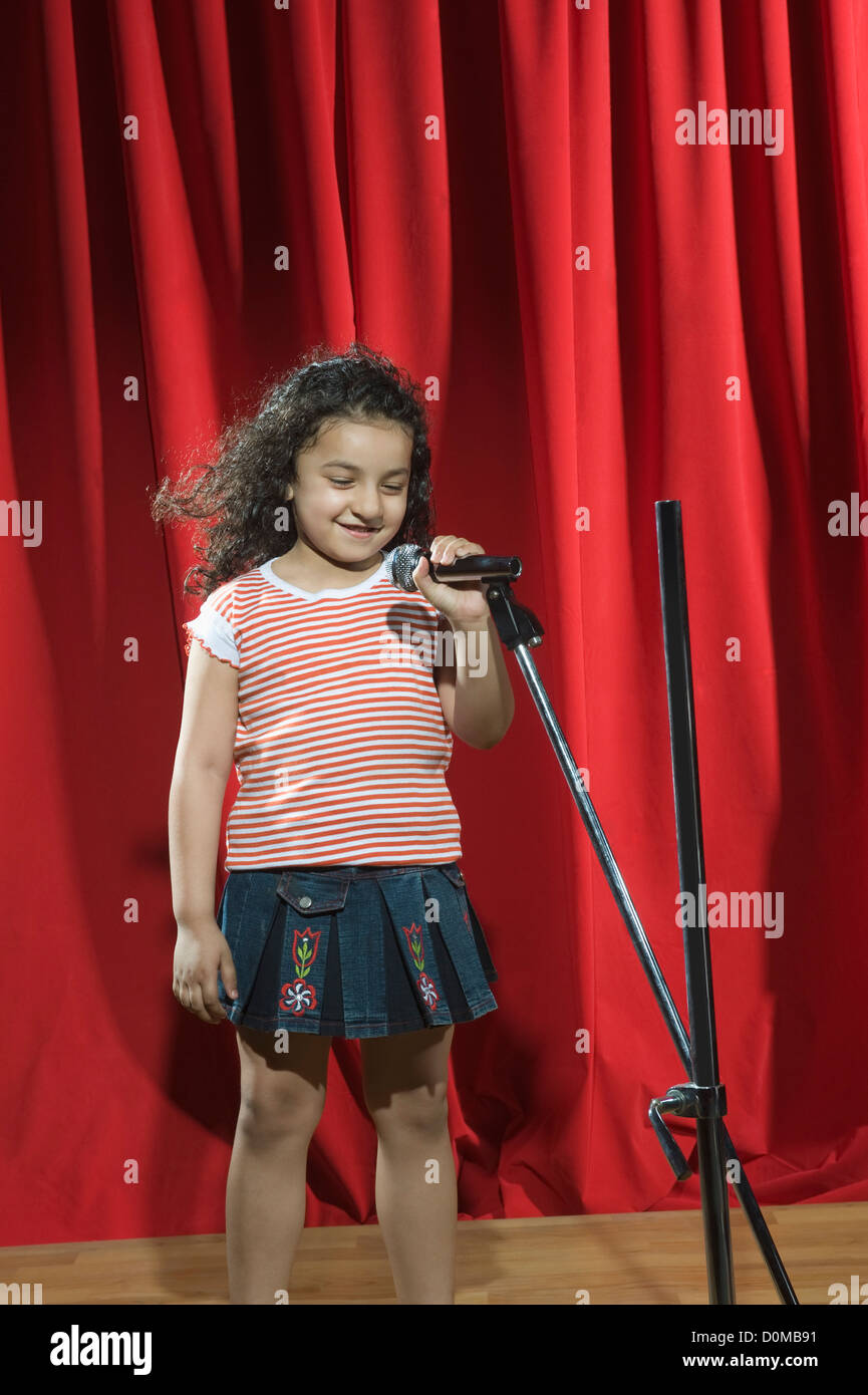 Girl performing with a microphone on a stage Stock Photo - Alamy