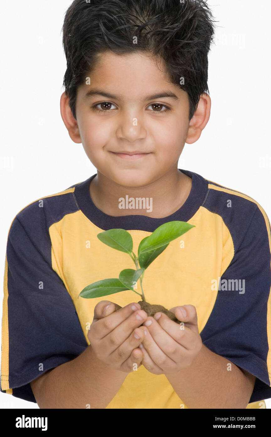 Close-up of a boy holding a plant Stock Photo - Alamy